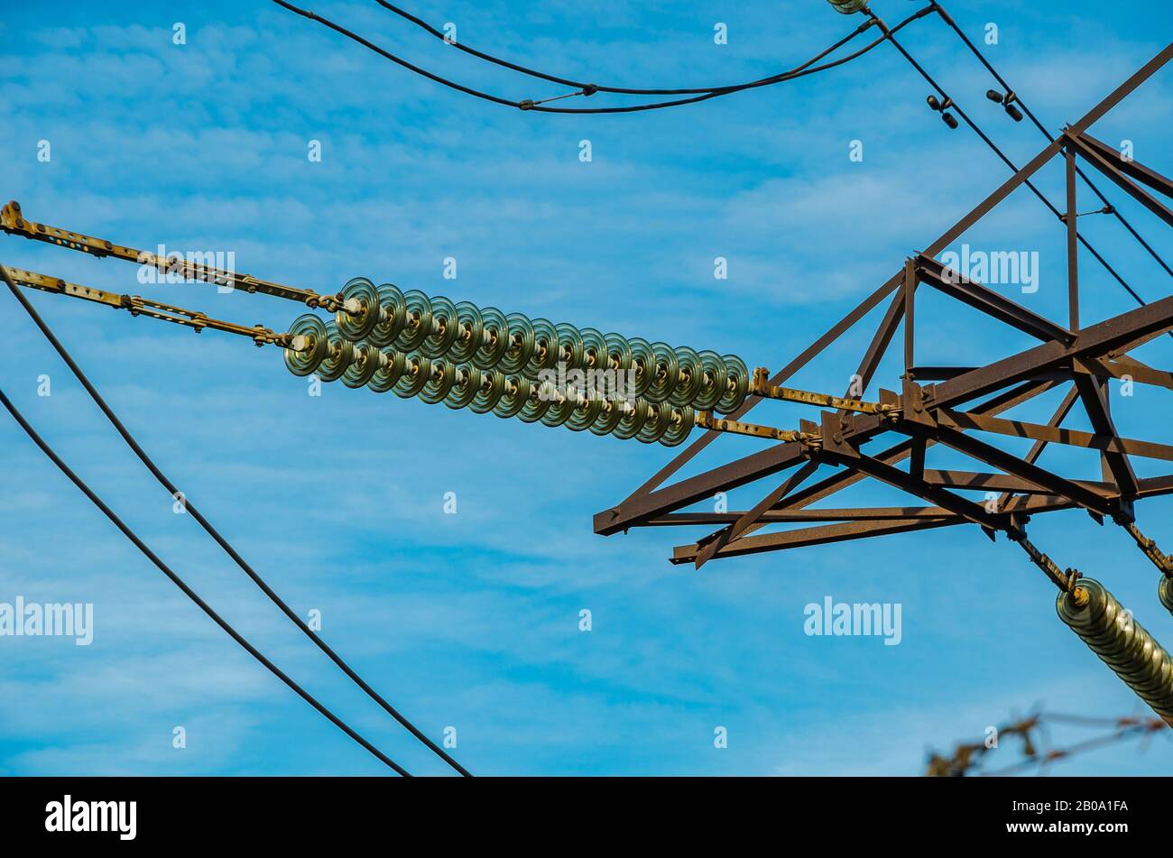Close-up of insulators on the wires of a tower of a high-voltage power ...