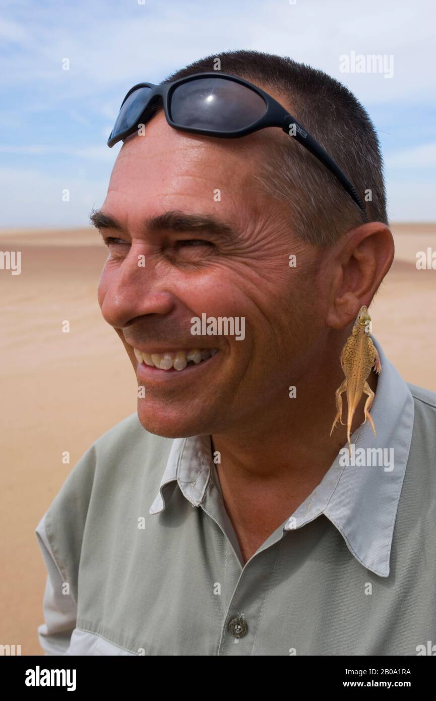 NAMIBIA, NEAR SWAKOPMUND, NAMIB DESERT, NATURE GUIDE TOMMY WITH SAND ...