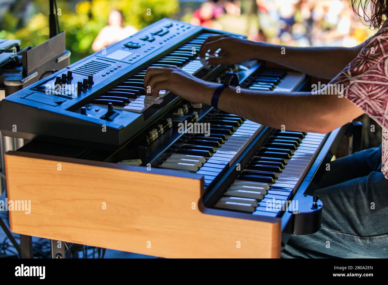 A close up shot of a young man playing an electronic keyboard and ...