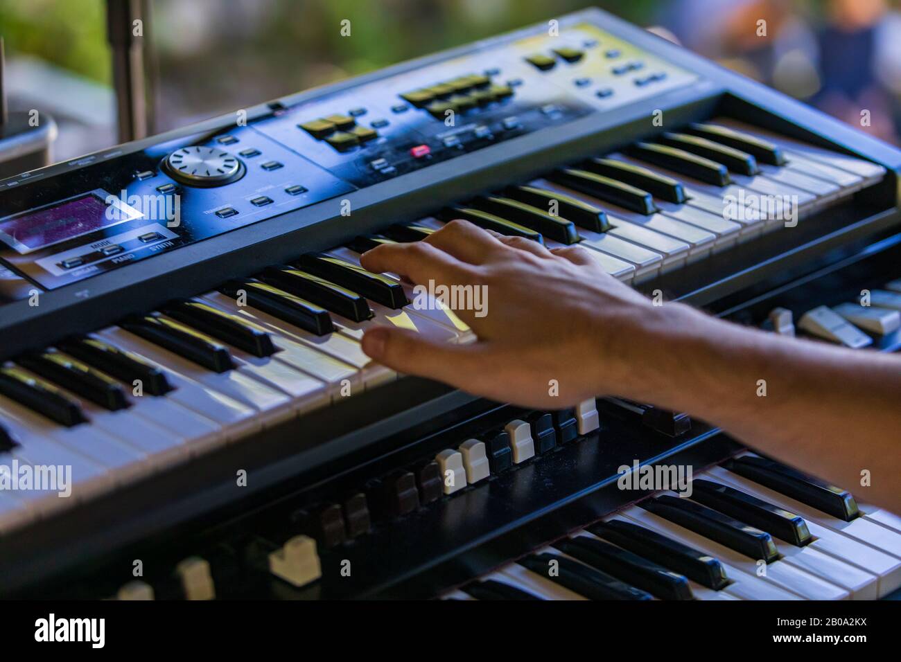 A close up soft focus view on the hand of a keyboardist playing an ...