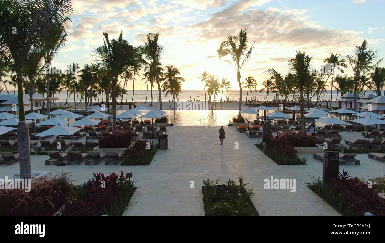 Romantic sunset in tropical resort with swimming pool, palm trees and ...