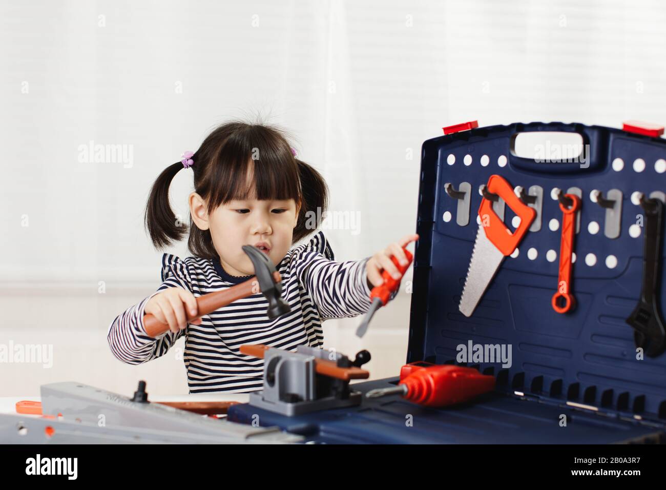 toddler girl pretend using DIY tool at home against white background ...