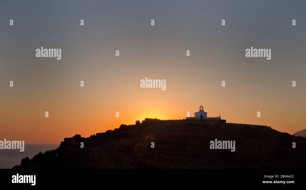 Sunrise over a small chapel on top of hills that overlook Panormos ...