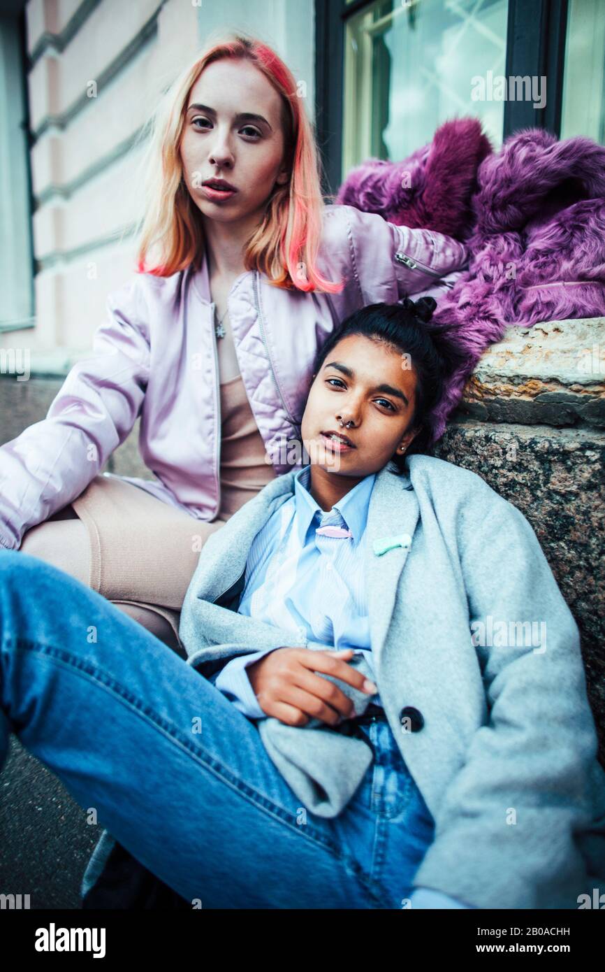 Two teenage girls infront of university building smiling, having fun ...