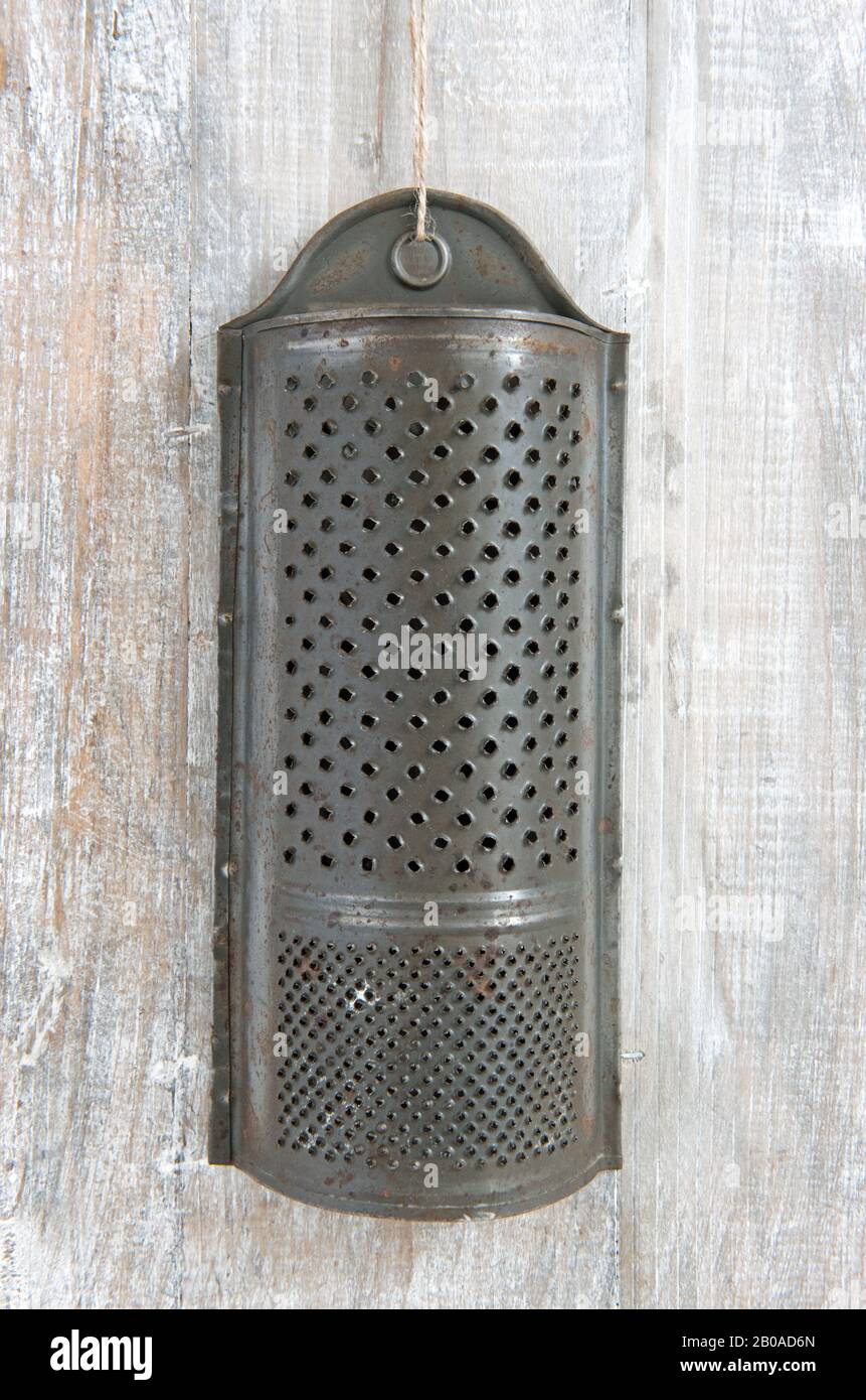 Vintage Cheese Grater hanging on wooden background Stock Photo - Alamy