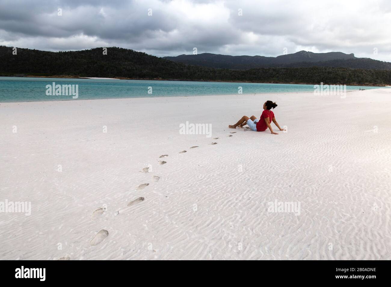 Tourist with man bun and red shirt at white sandy Australian beach ...
