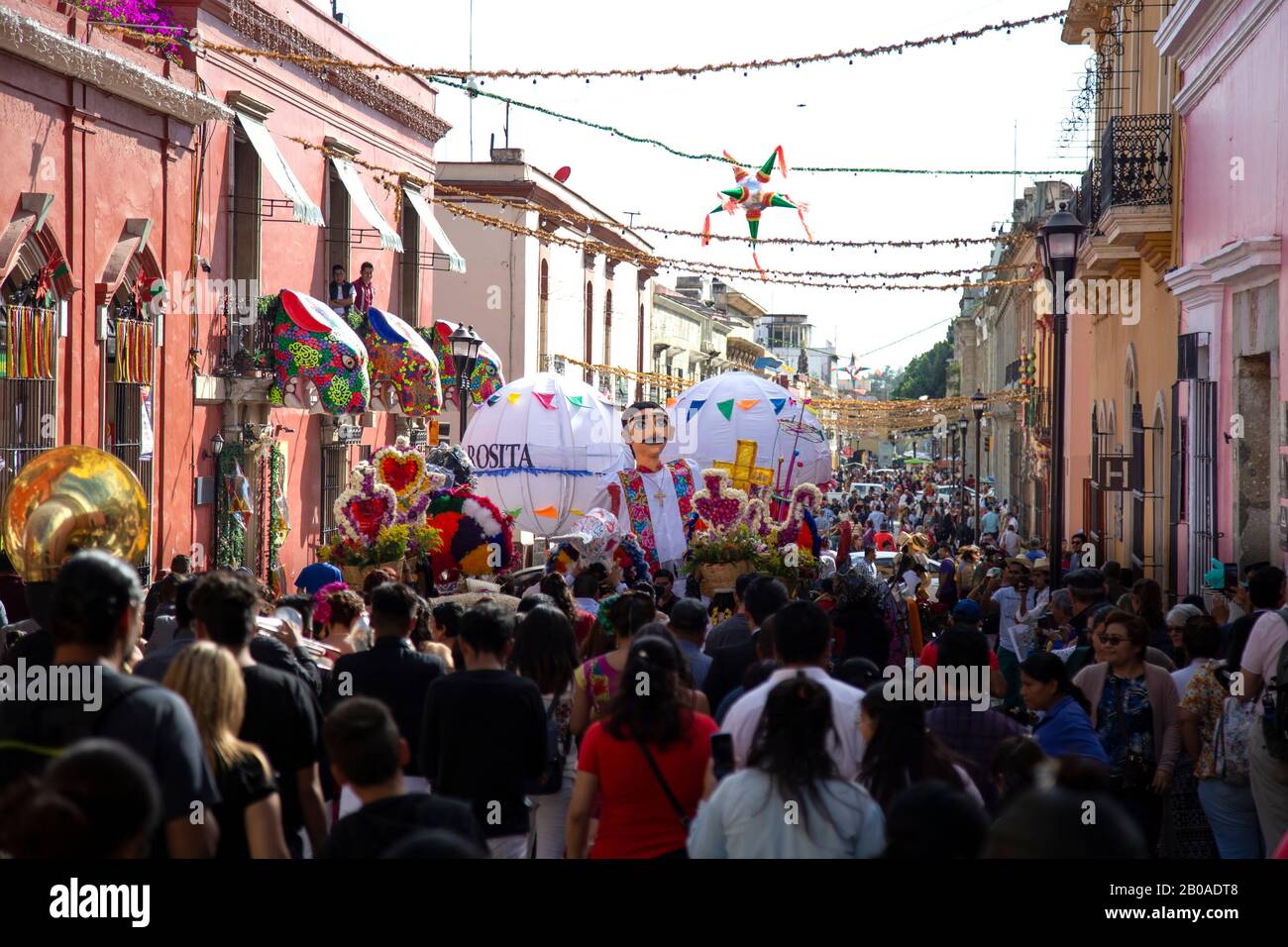 Crowd following a celebration (Calenda), on colonial street of Mexico ...