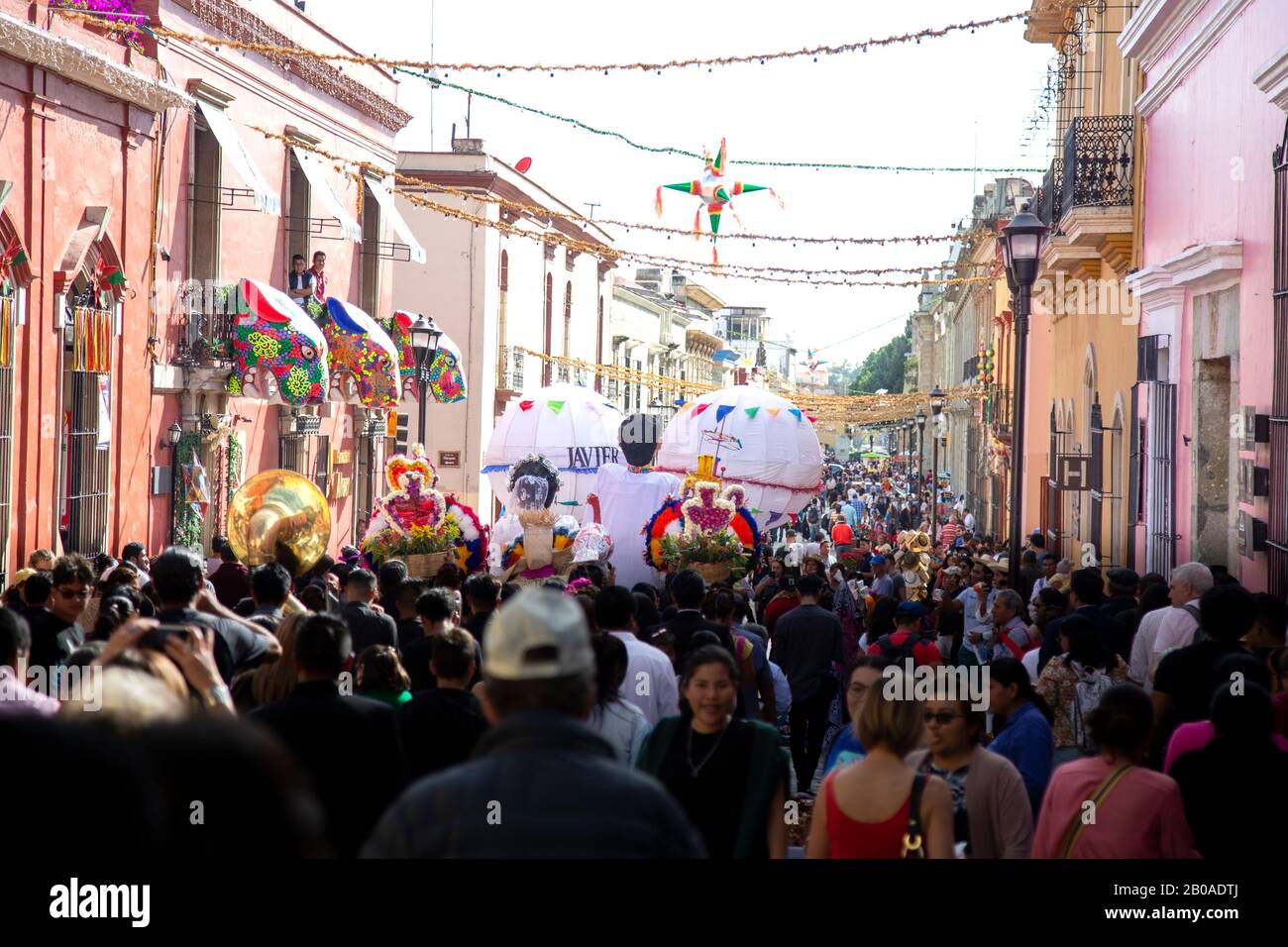 Crowd following a celebration (Calenda), on colonial street of Mexico ...