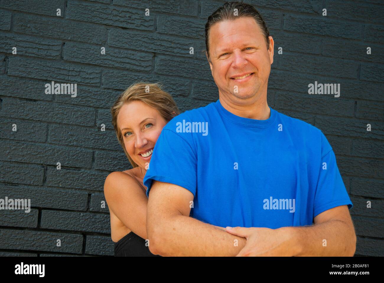 Couple posing at brick wall Stock Photo - Alamy
