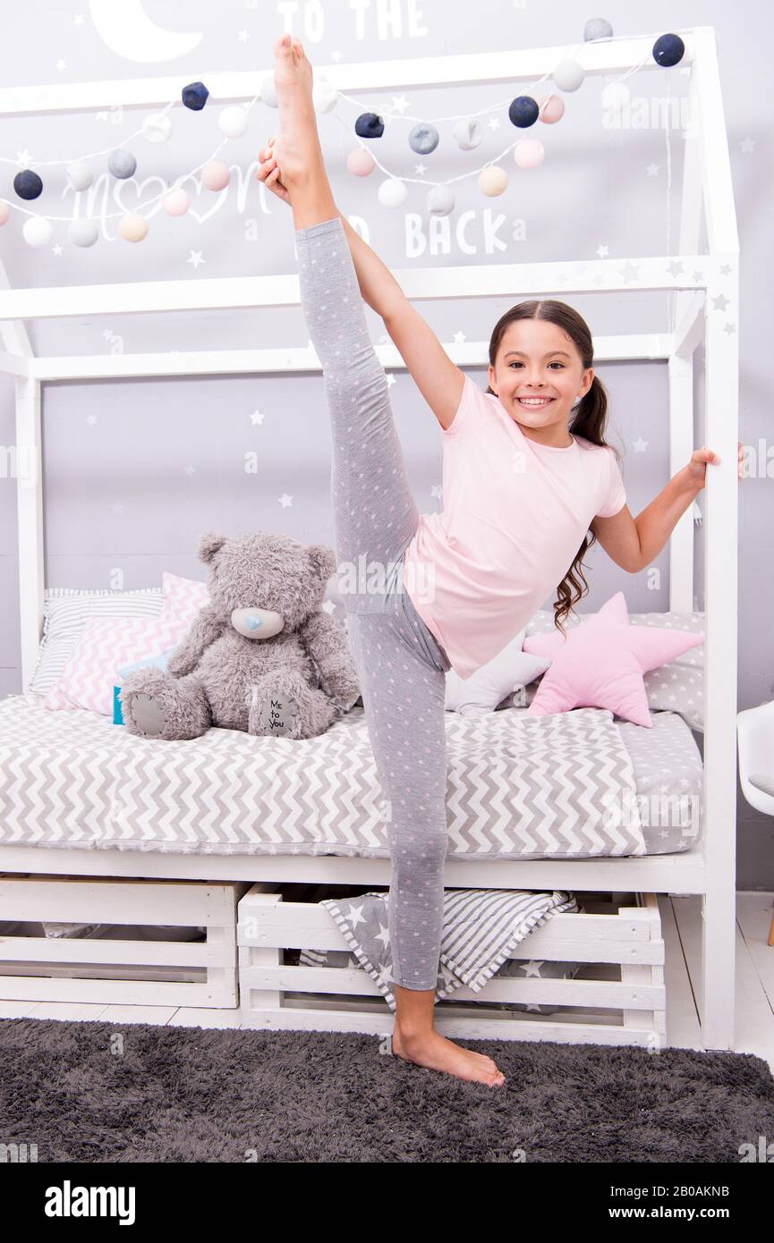Improve flexibility. Girl child split in bedroom. Kid prepare go to bed ...