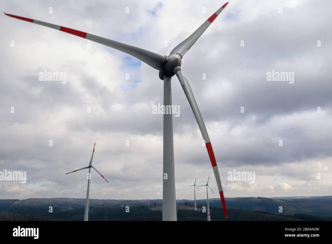wind wheels in front a forest hills landscape Stock Photo - Alamy