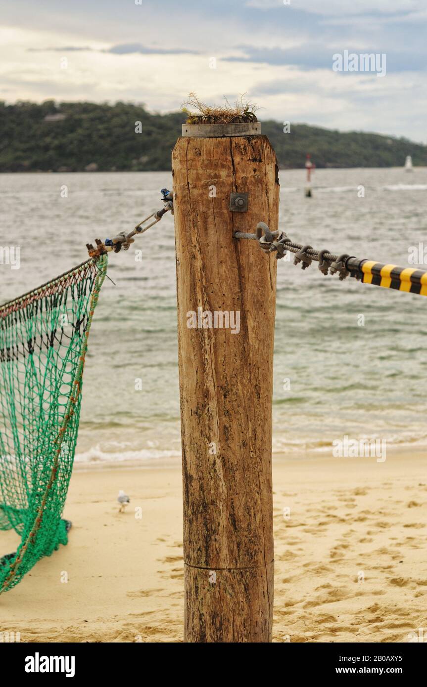 Detail of the green shark net and weathered support post, cable, and ...