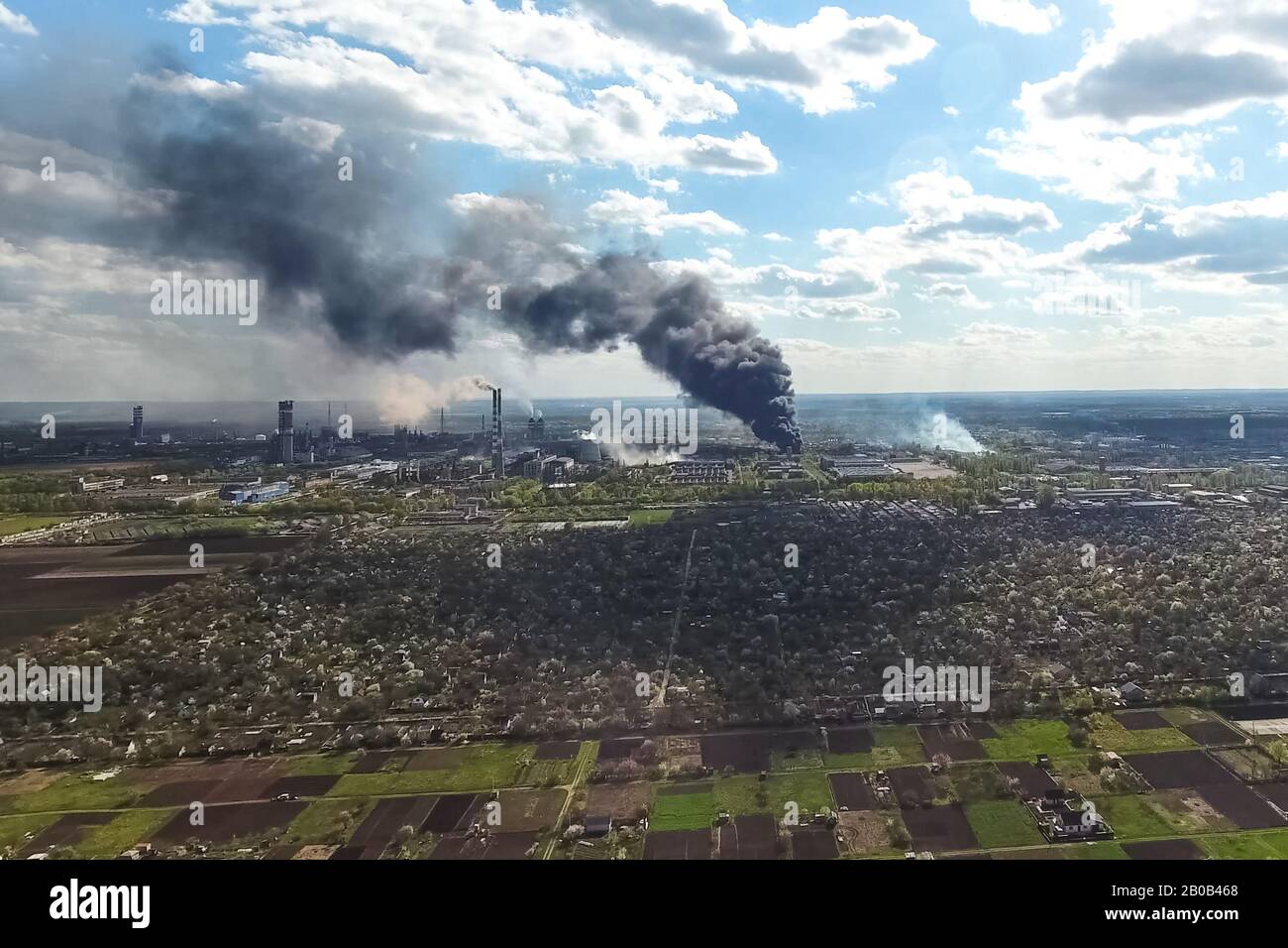 A major fire at the factory. dark puffs of smoke from buildings Stock ...