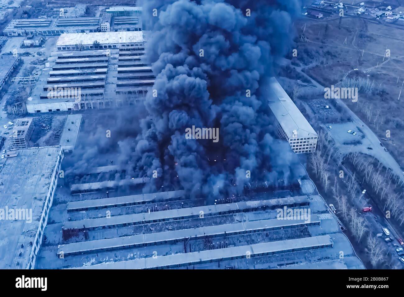 A major fire at the factory. dark puffs of smoke from buildings Stock ...