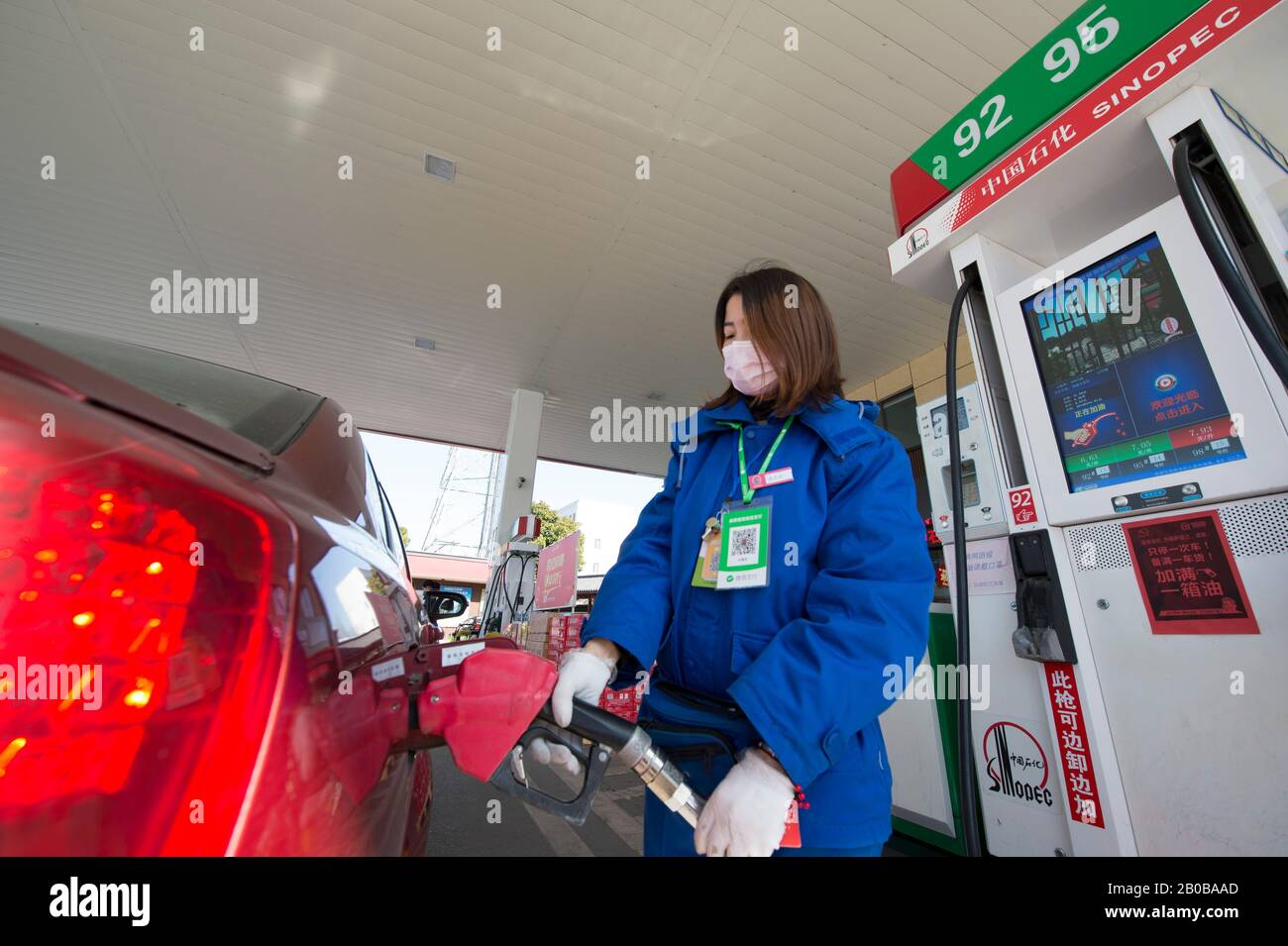 A Chinese worker refuels car at a gas station of Sinopec in Hai'an City ...