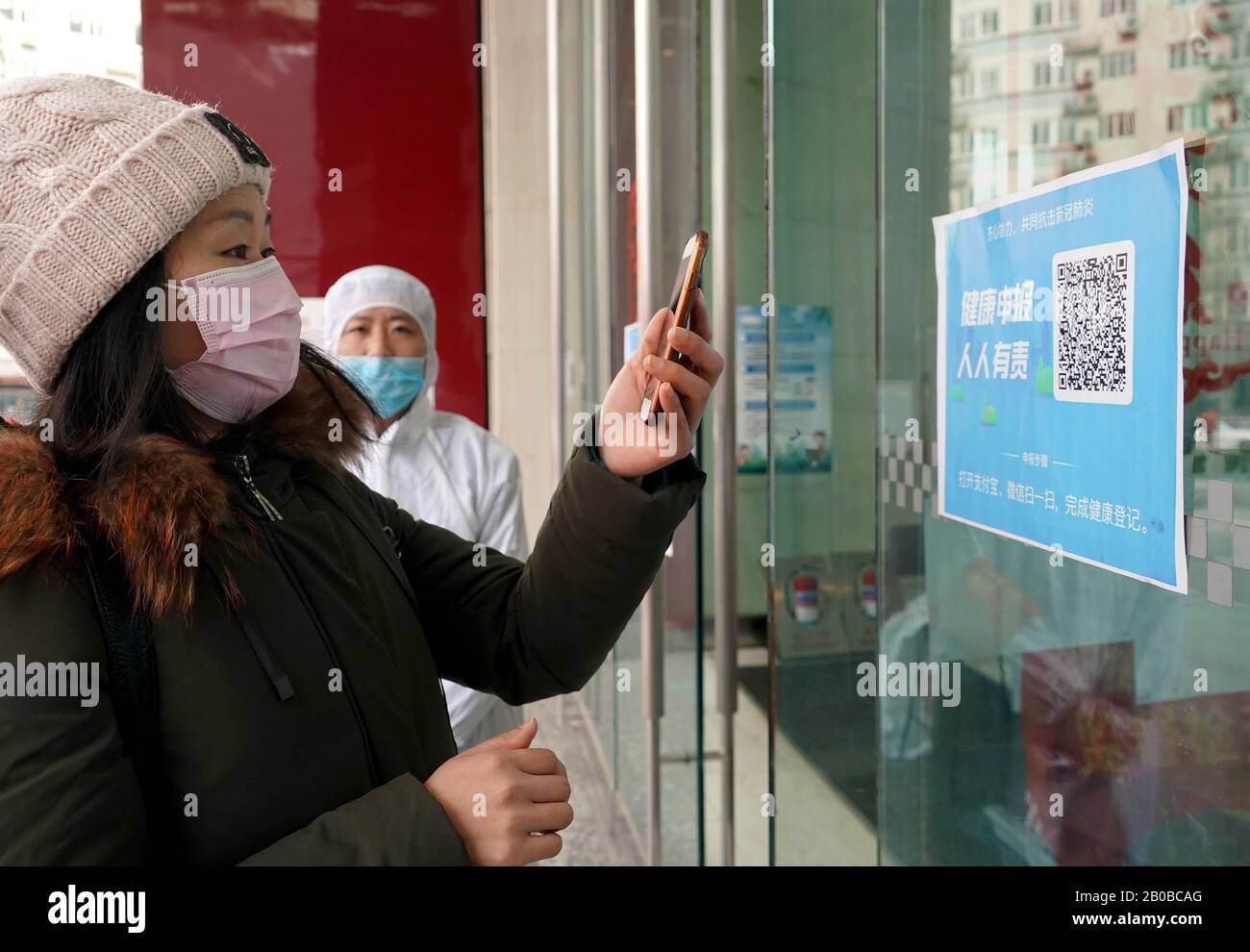 Zhengzhou, China. 19th Feb 2020. A resident scans a QR code at an ...