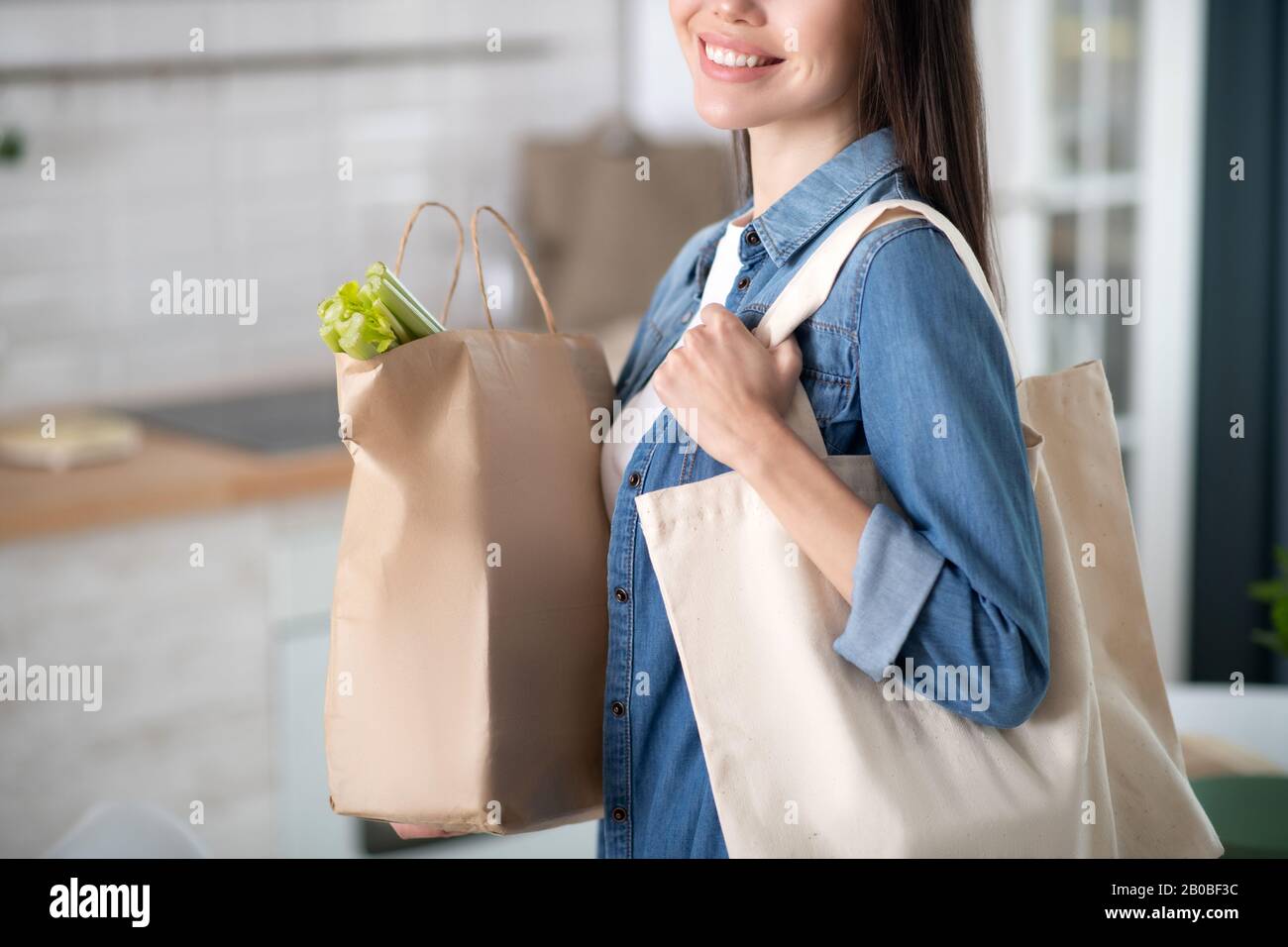 Woman with paper bag and fabric bag on his shoulder Stock Photo - Alamy
