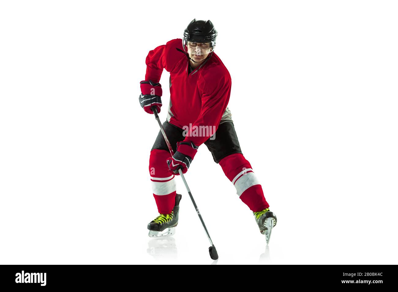 On the run. Male hockey player with the stick on ice court and white ...