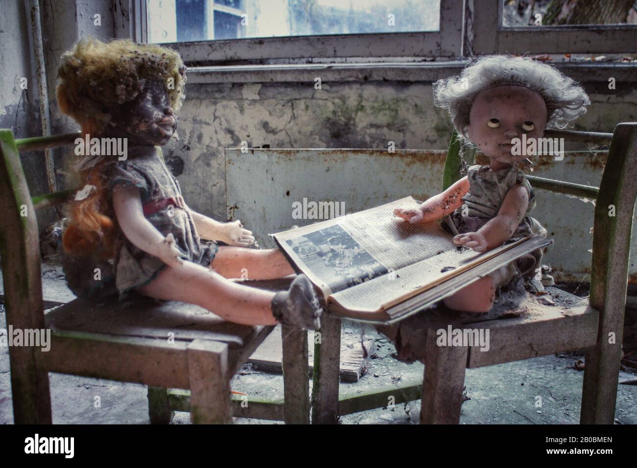 Creepy dolls on toy chairs with a book in an abandoned building in ...