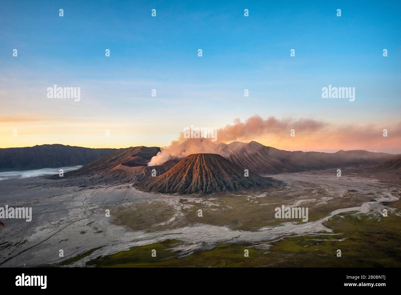 Volcanic landscape at sunrise, smoking volcano Gunung Bromo, with Mt ...