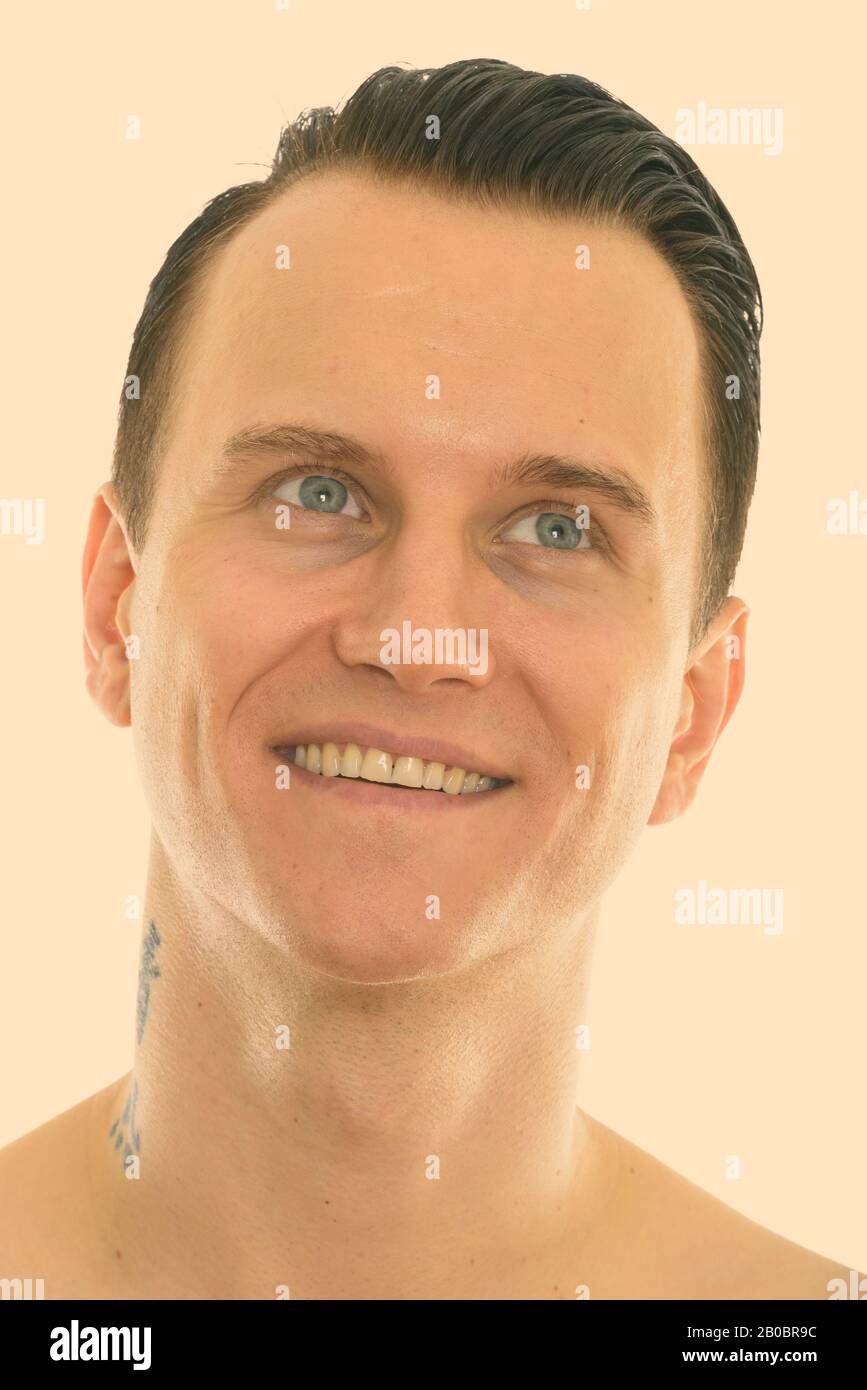 Face of young happy man smiling while thinking and looking up Stock ...