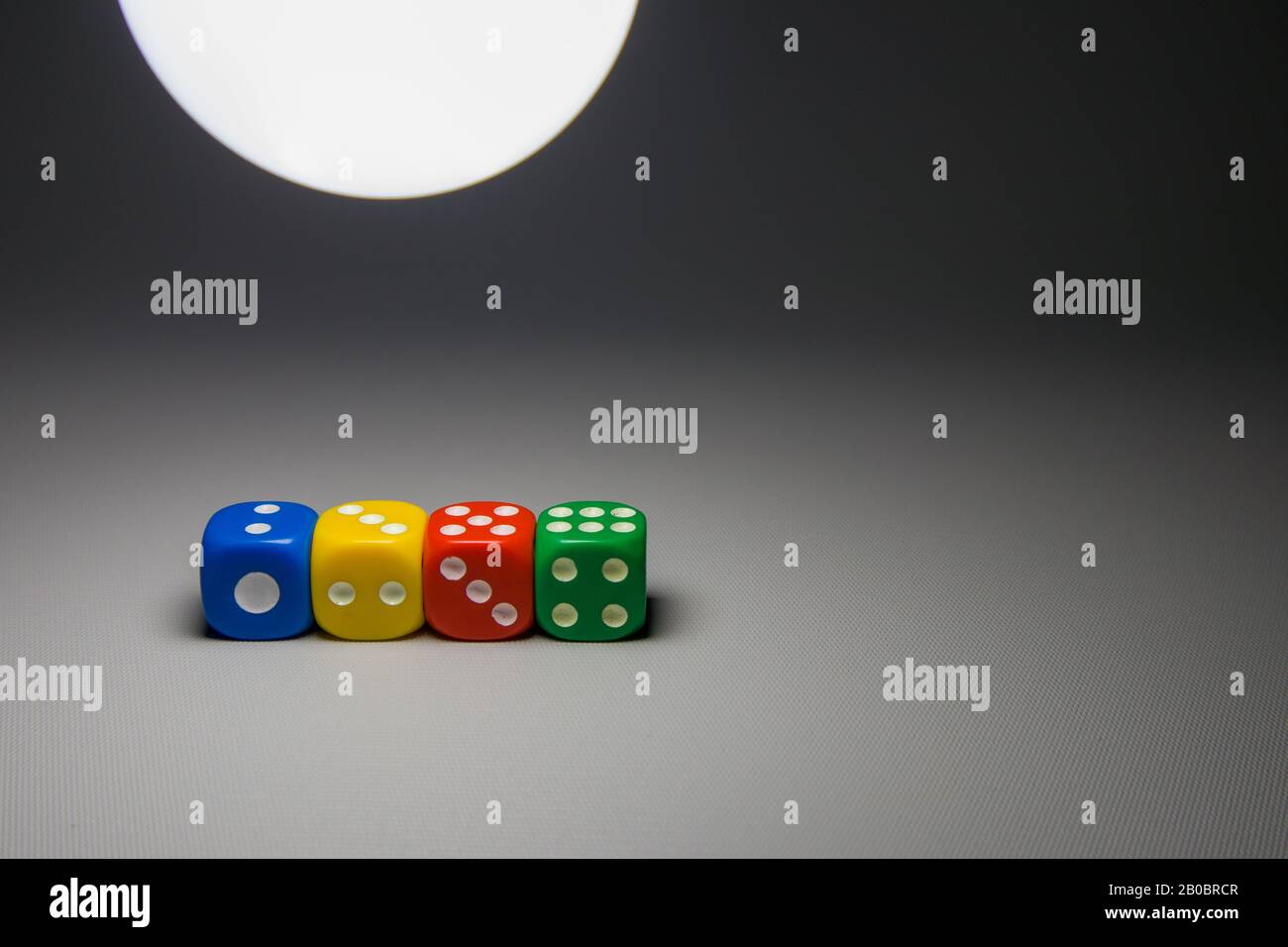 color dice with numbers on grey background with light from a lamp Stock ...