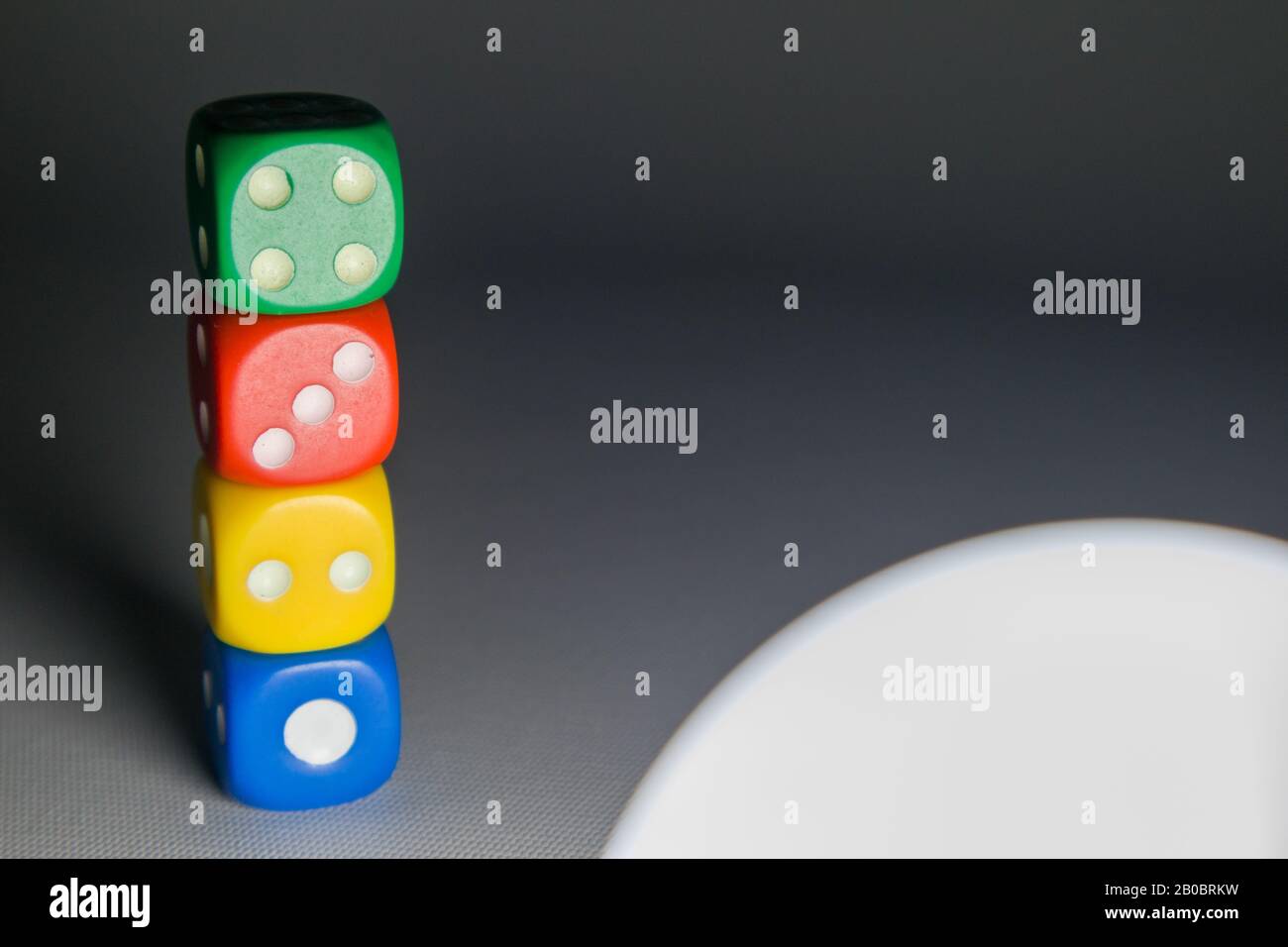 four color dice on grey background with light from a lamp Stock Photo ...