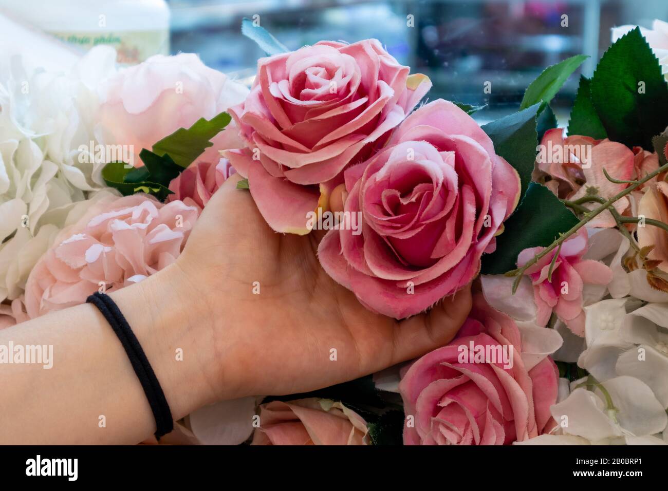 Female left hand holds red roses in bouquet Stock Photo - Alamy