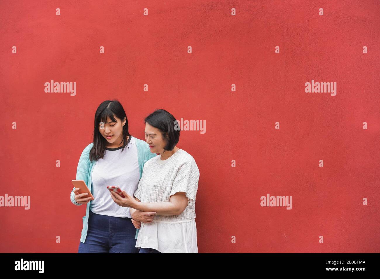 Asian mother and daughter using smartphone app - Happy family people ...