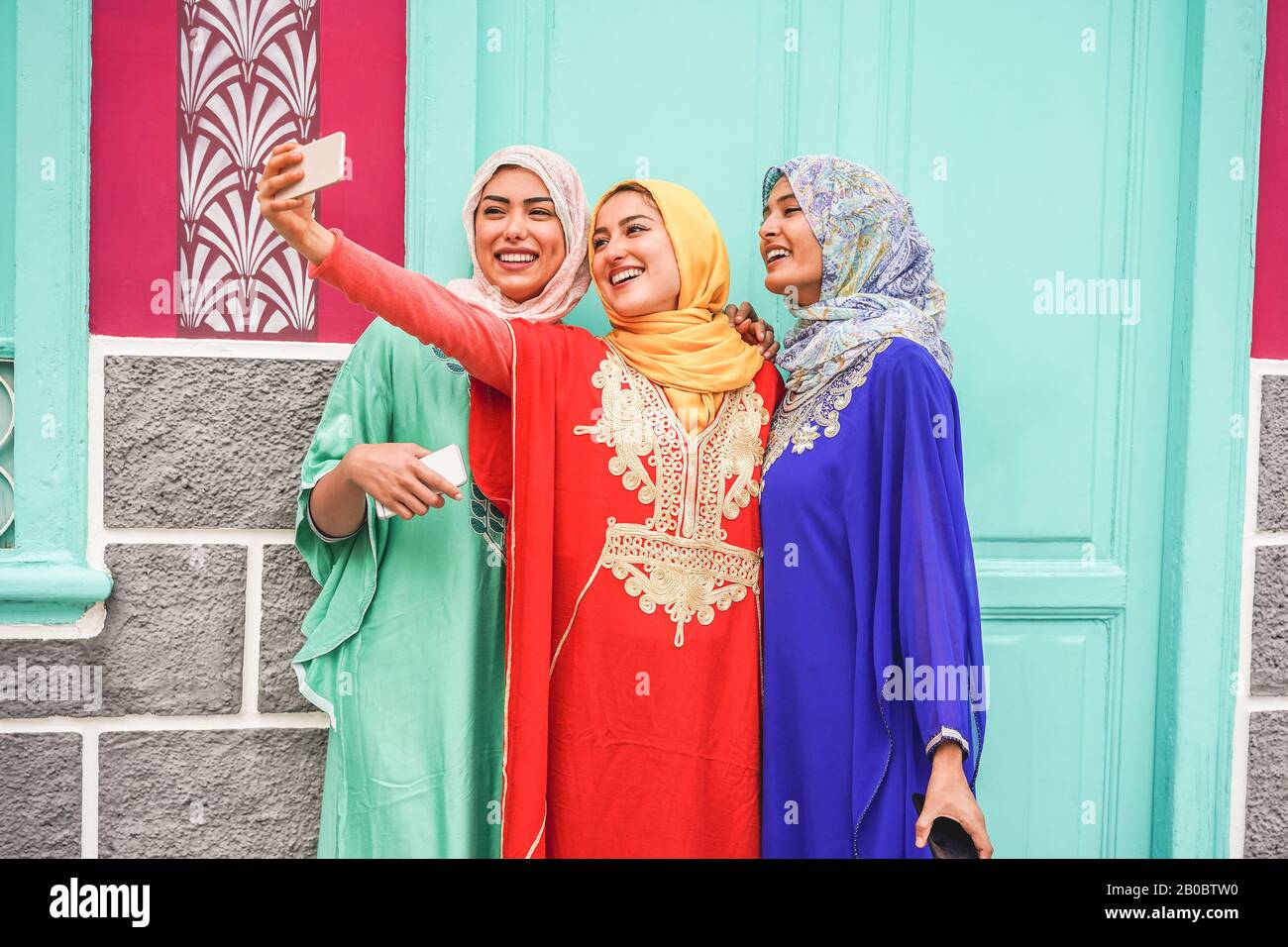 Happy arabian friends using smartphone for making selfie story on ...
