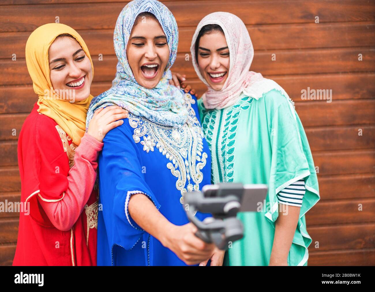 Happy arabian friends using smartphone for making video vlog on social ...