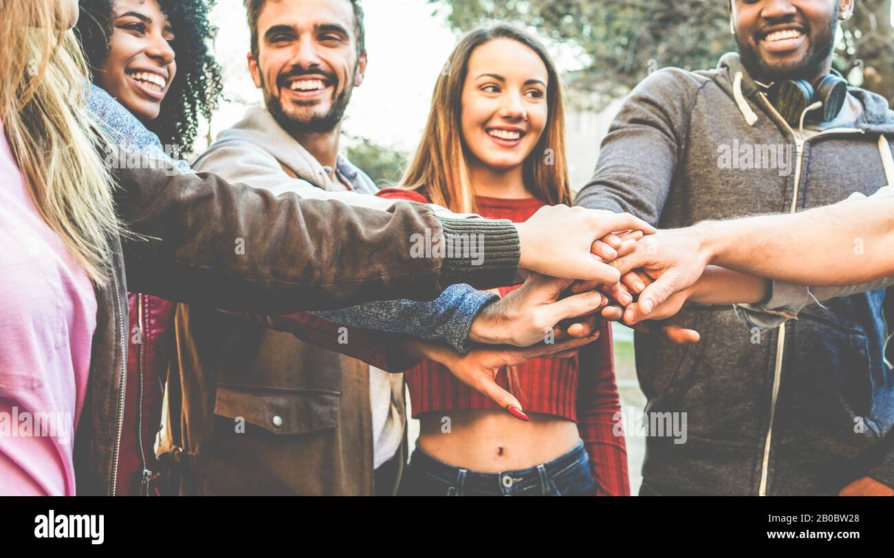 Young friends stacking hands together - Happy students people ...