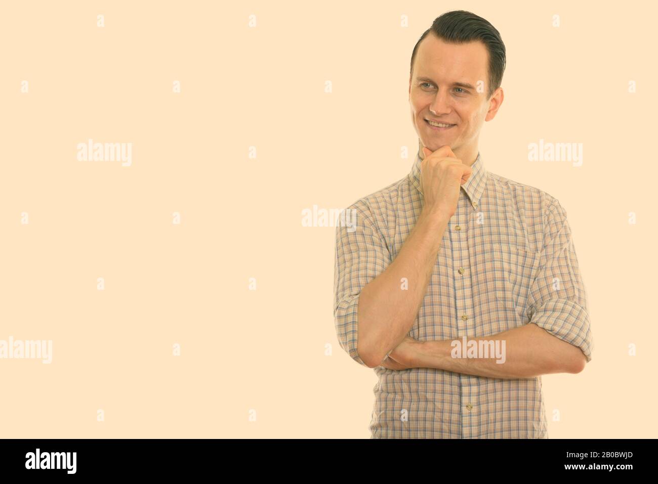 Studio shot of young happy man smiling and thinking Stock Photo - Alamy