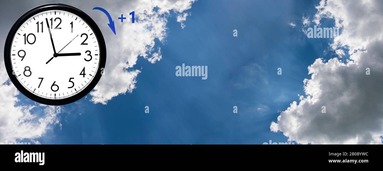 Daylight Saving Time (DST). Blue sky with white clouds and clock. Turn ...