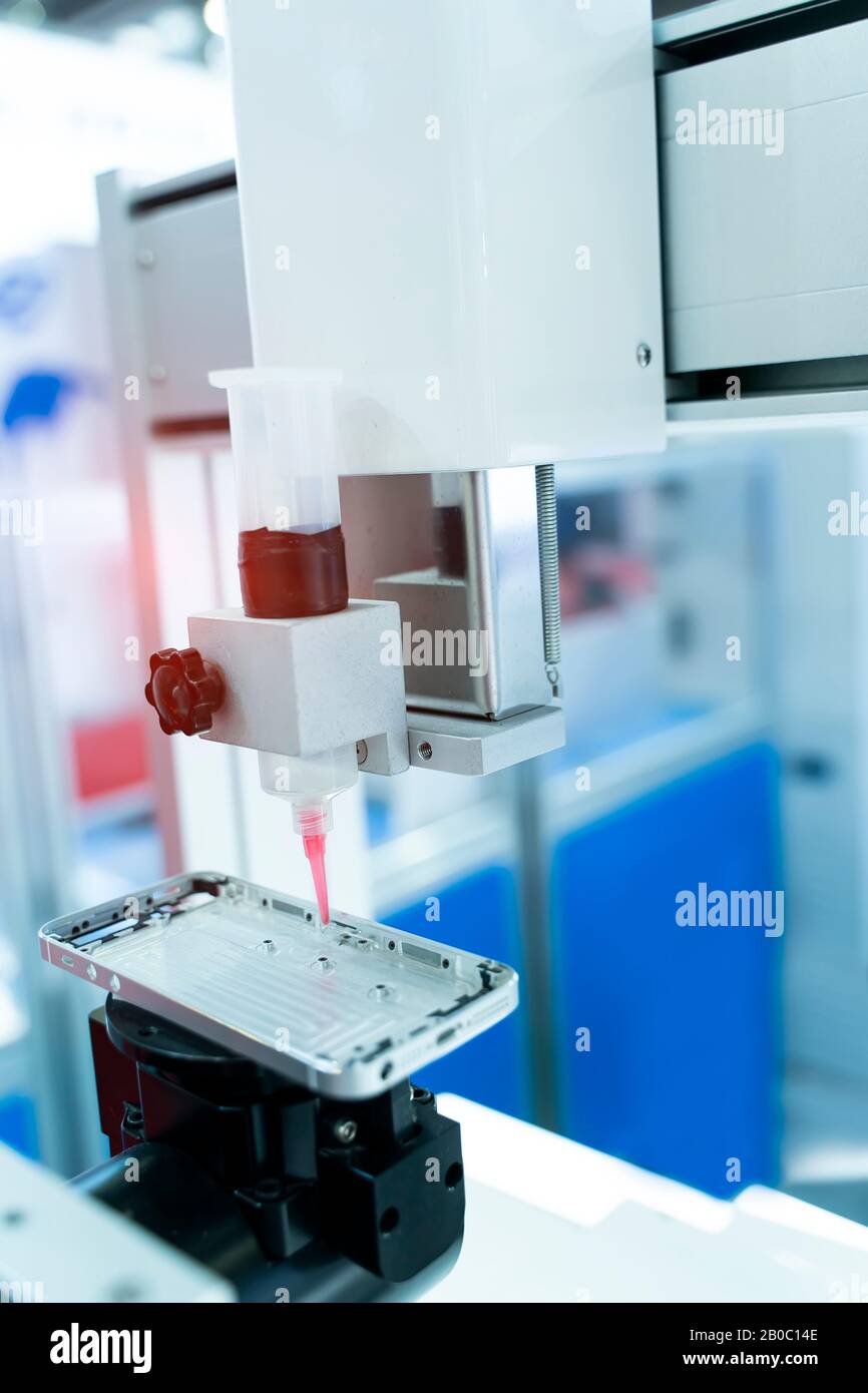 Robot holding glue syringe Injection in mobile phone factory Stock ...