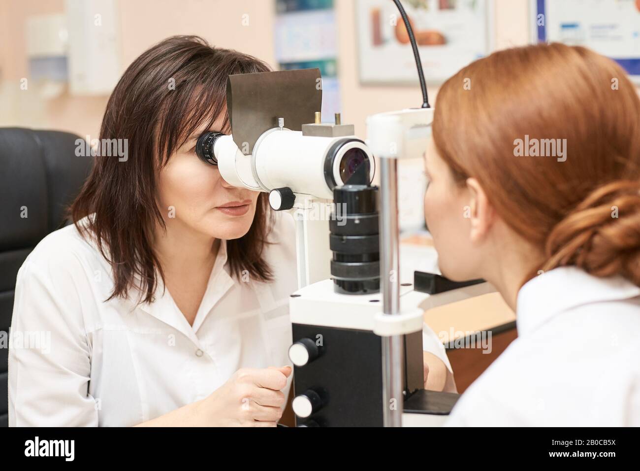 ophthalmologist doctor in exam optician laboratory with female patient ...