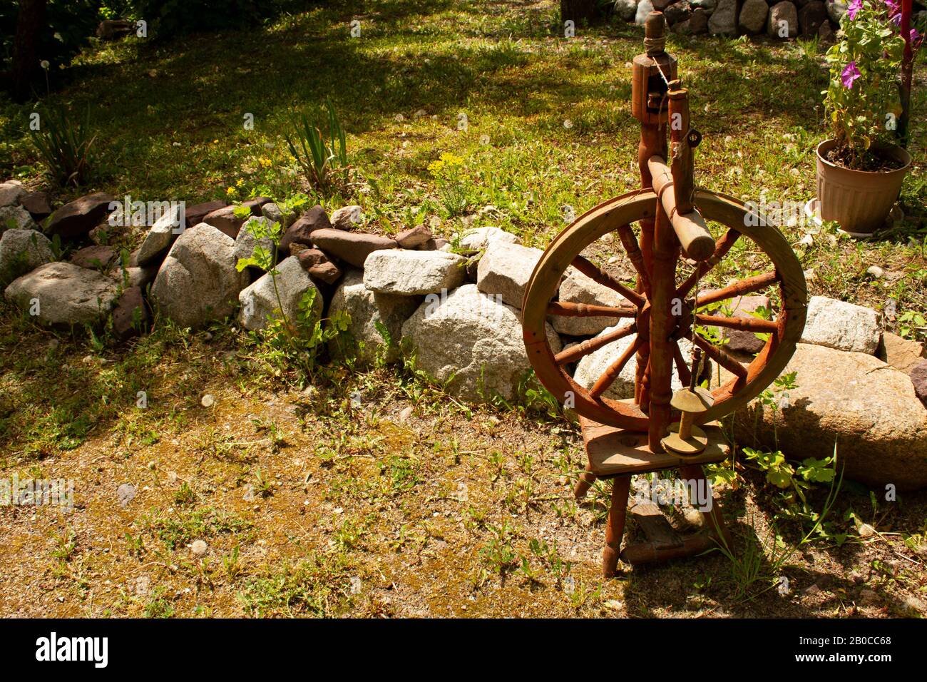 Ancient wooden spinning wheel with wheel and spindle in the garden on ...