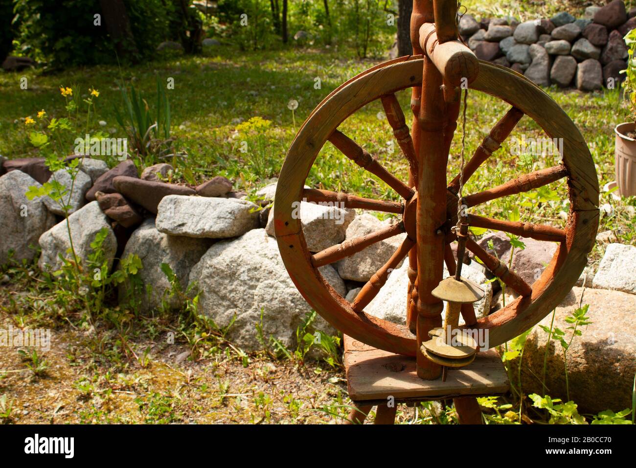 Ancient wooden spinning wheel with wheel and spindle in the garden on ...