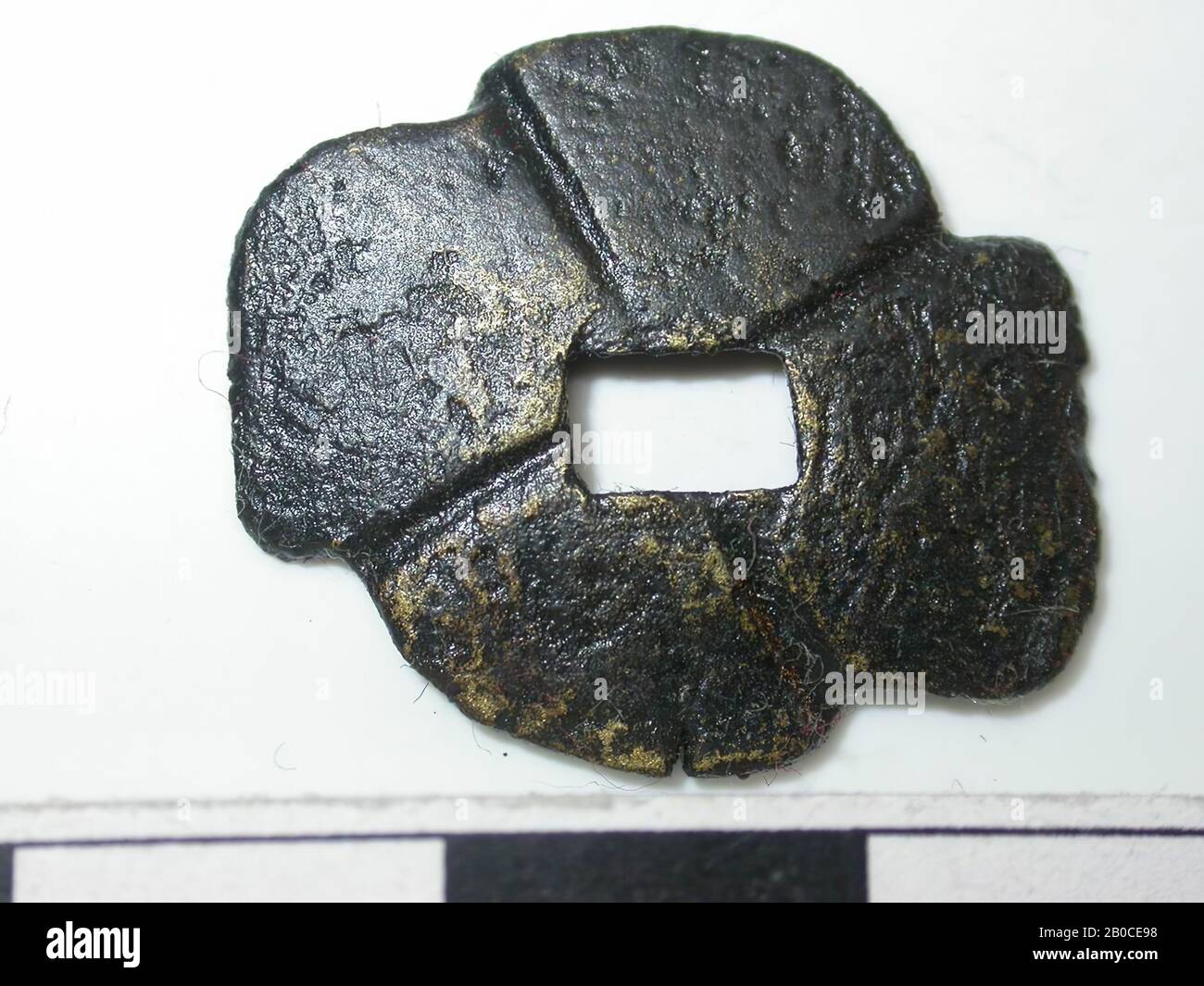 4-lobe figure, dark with gold-colored spots (copper alloy). 4-lobed ...