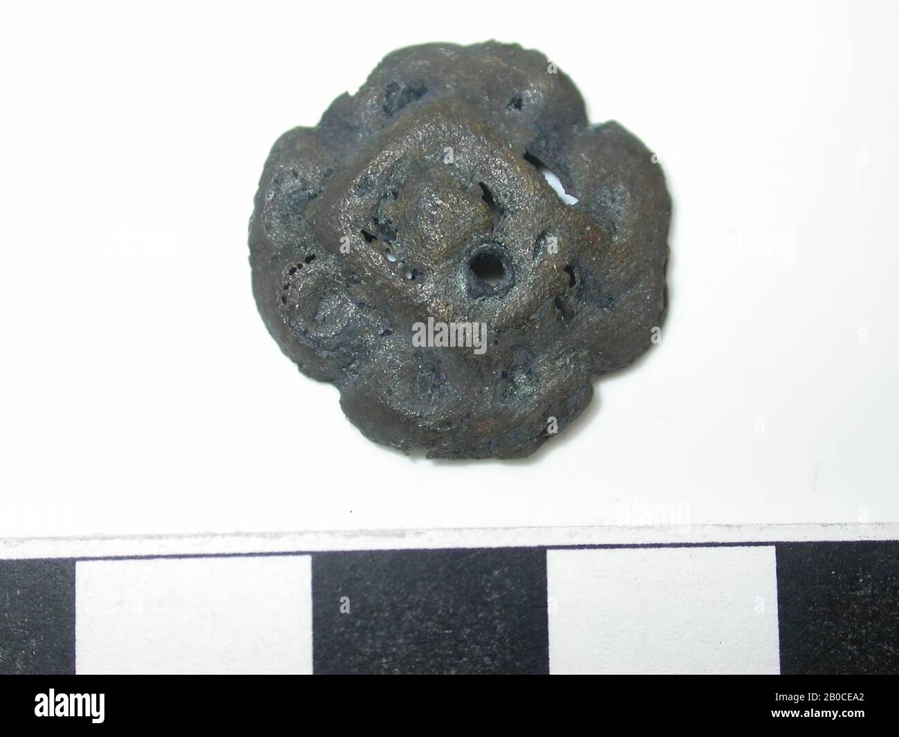 4-lobe figure, dark with gold-colored spots (copper alloy). 4-lobed ...