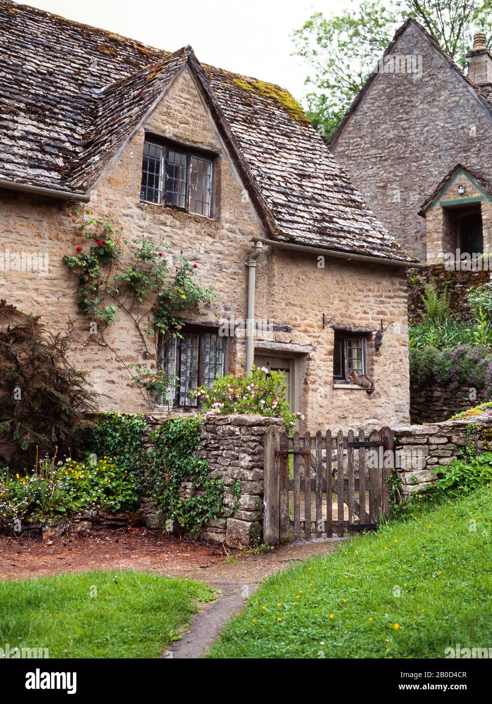 A Cotswold traditional cottage, cat on window sill Stock Photo - Alamy