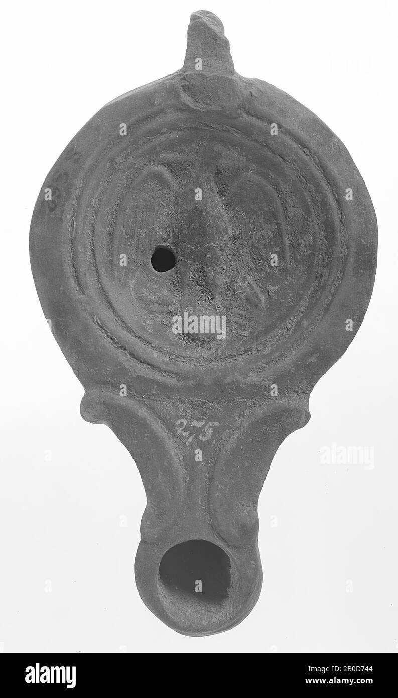 A red-burned oil lamp with a round body on a recessed pedestal. The ...