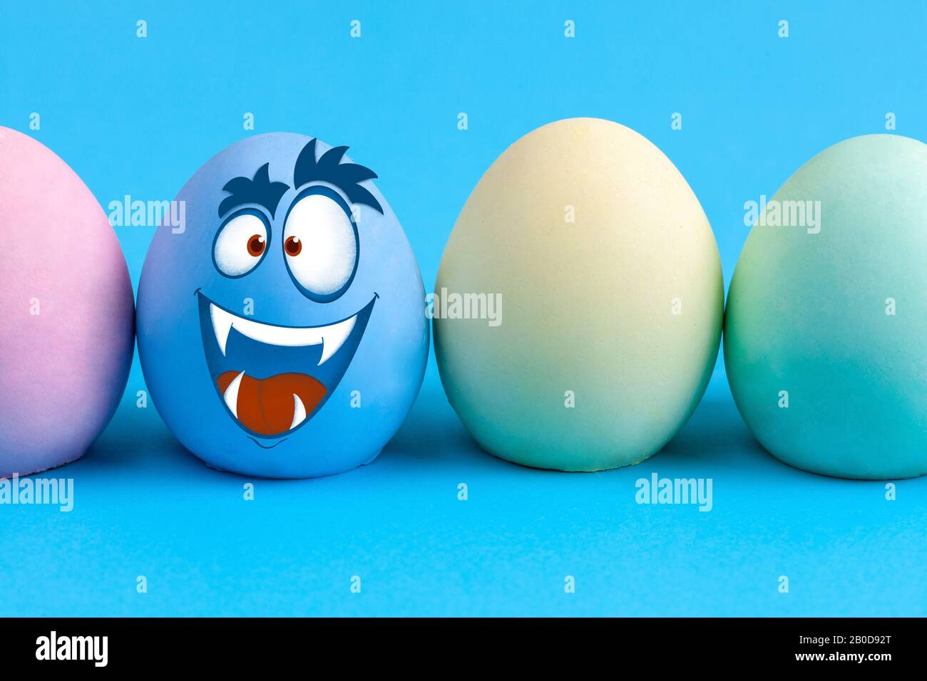 Smiling happy cartoon monster face on colorful easter egg with copy ...