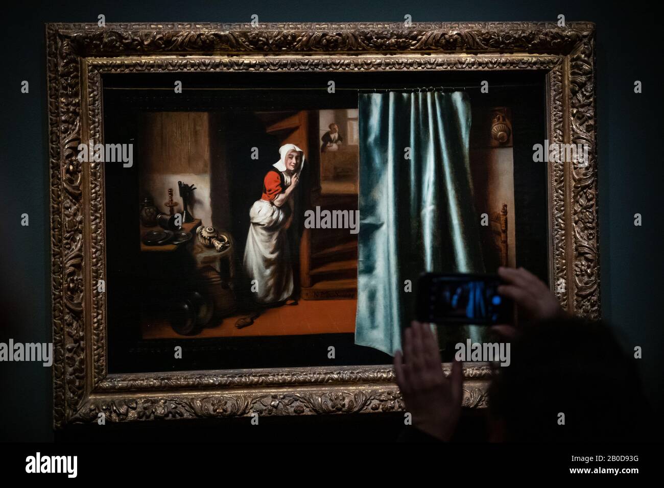A gallery visitor photographs The Eavesdropper by Nicolaes Maes at a ...