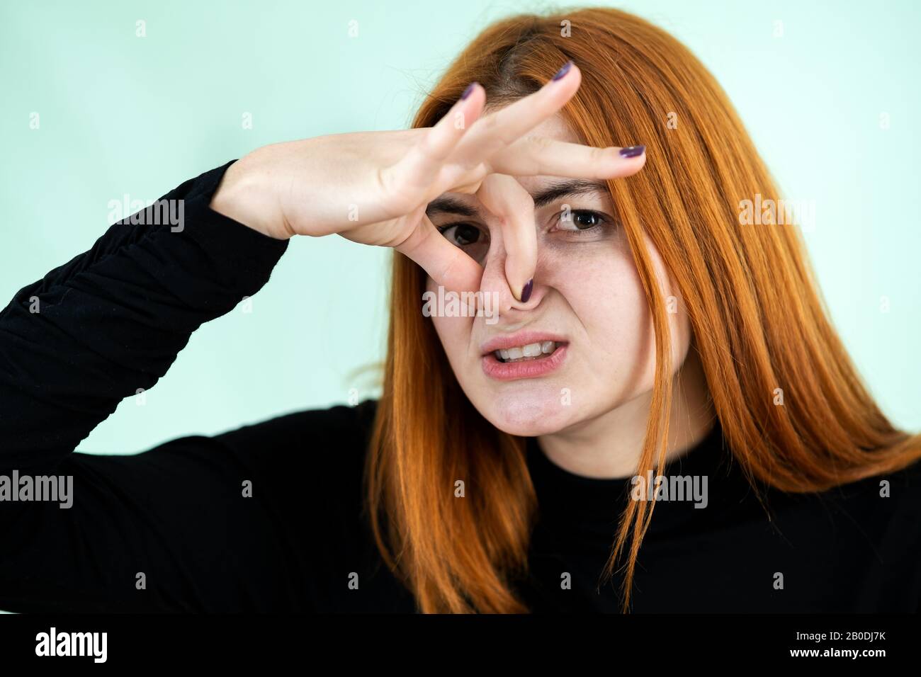 Funny pretty redhead girl showing bad smell sign with her fingers Stock ...