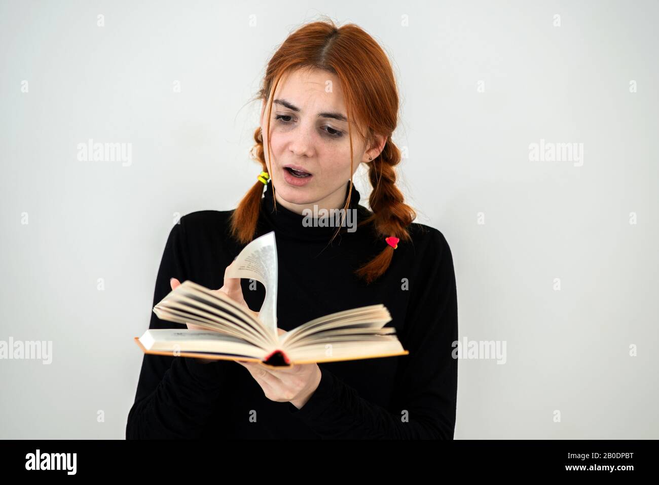 Young pretty girl read an open book in her hands. Reading and education ...