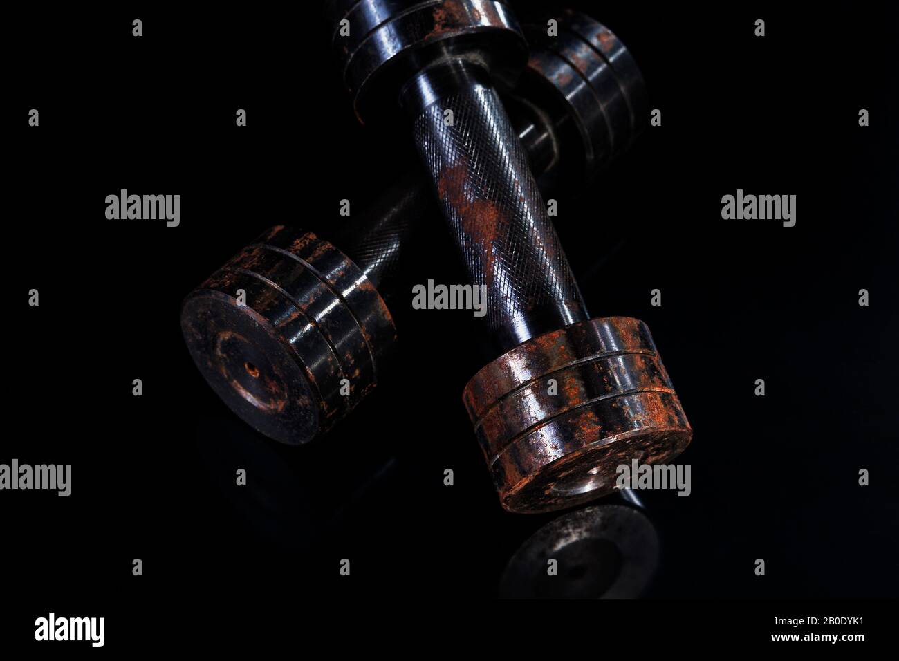 Two old rusty dumbbells on black background Stock Photo - Alamy