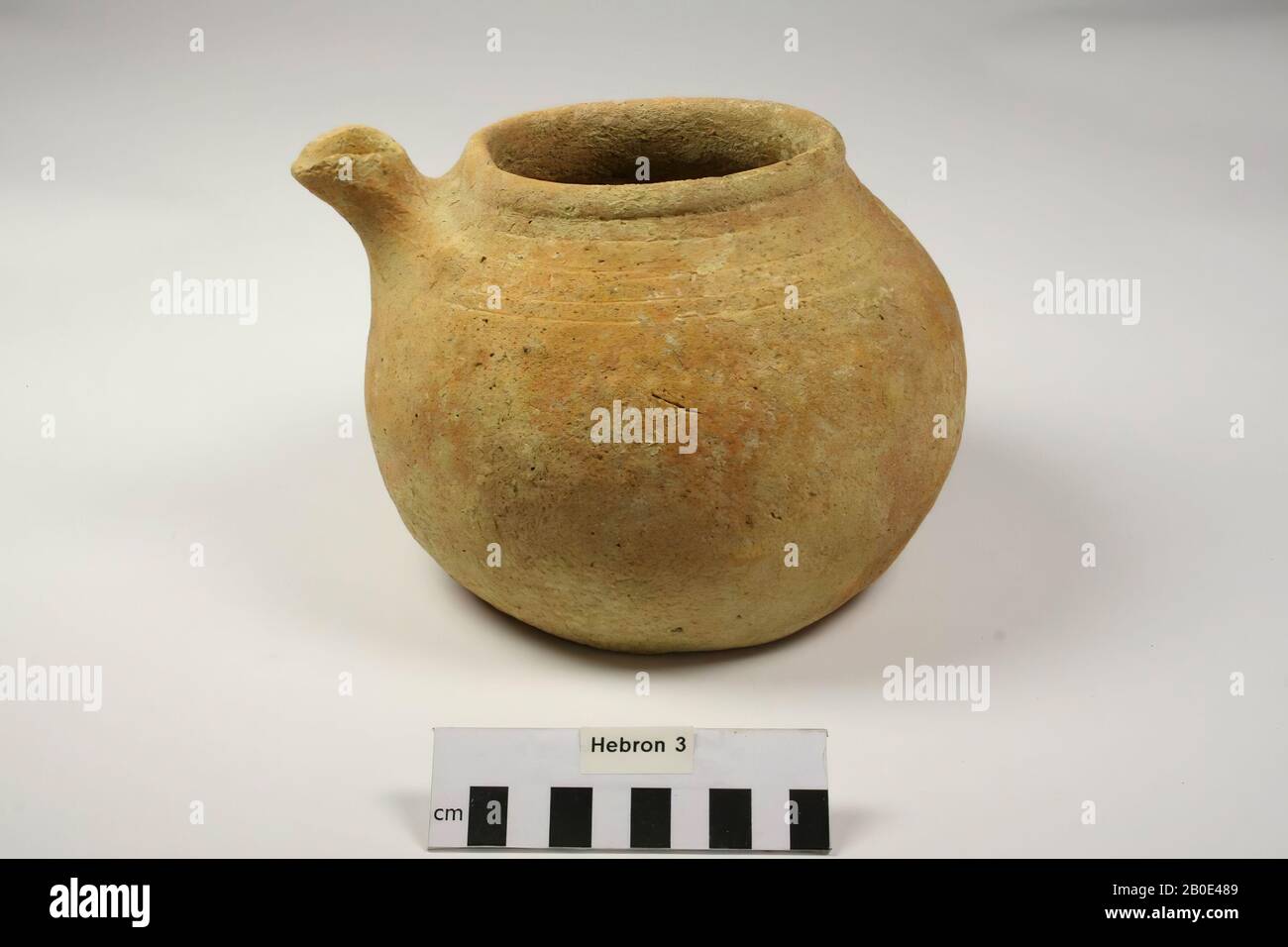 A large earthenware pot with spout, thickened edge and some horizontal ...