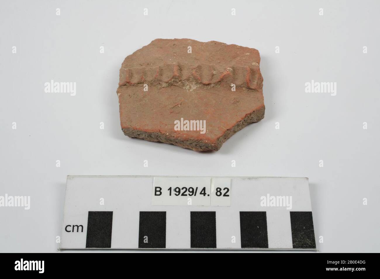An earthenware wall chard decorated with clay scroll with notches ...