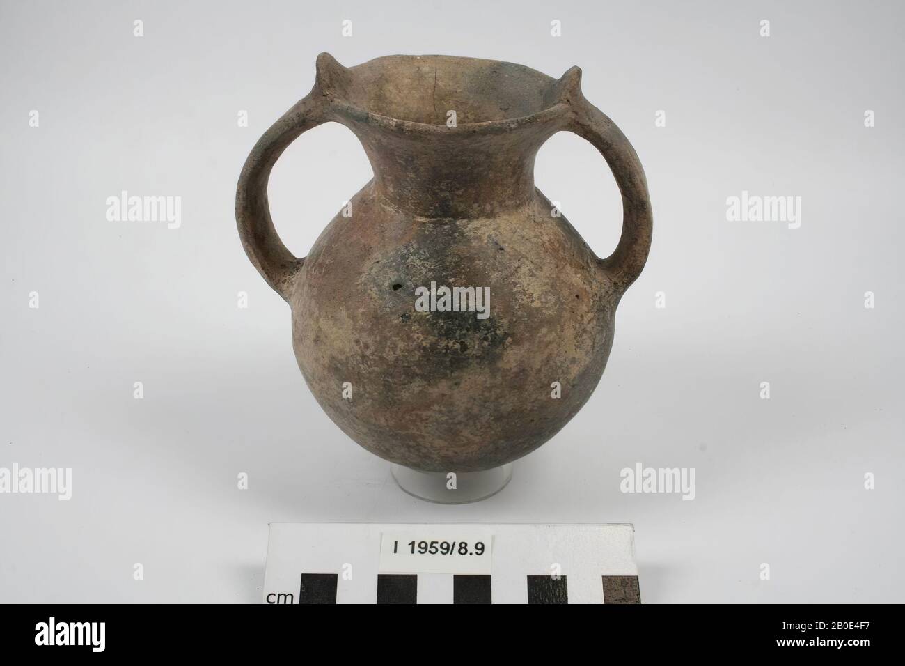 A globular earthenware jug with funnel spout and two ears. The ...